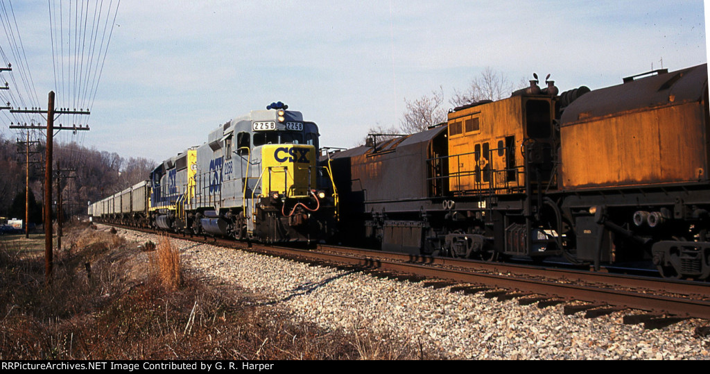 CSXT 2258 with a ballast train in tow passes a Loram rail grinder in the siding at Reusens